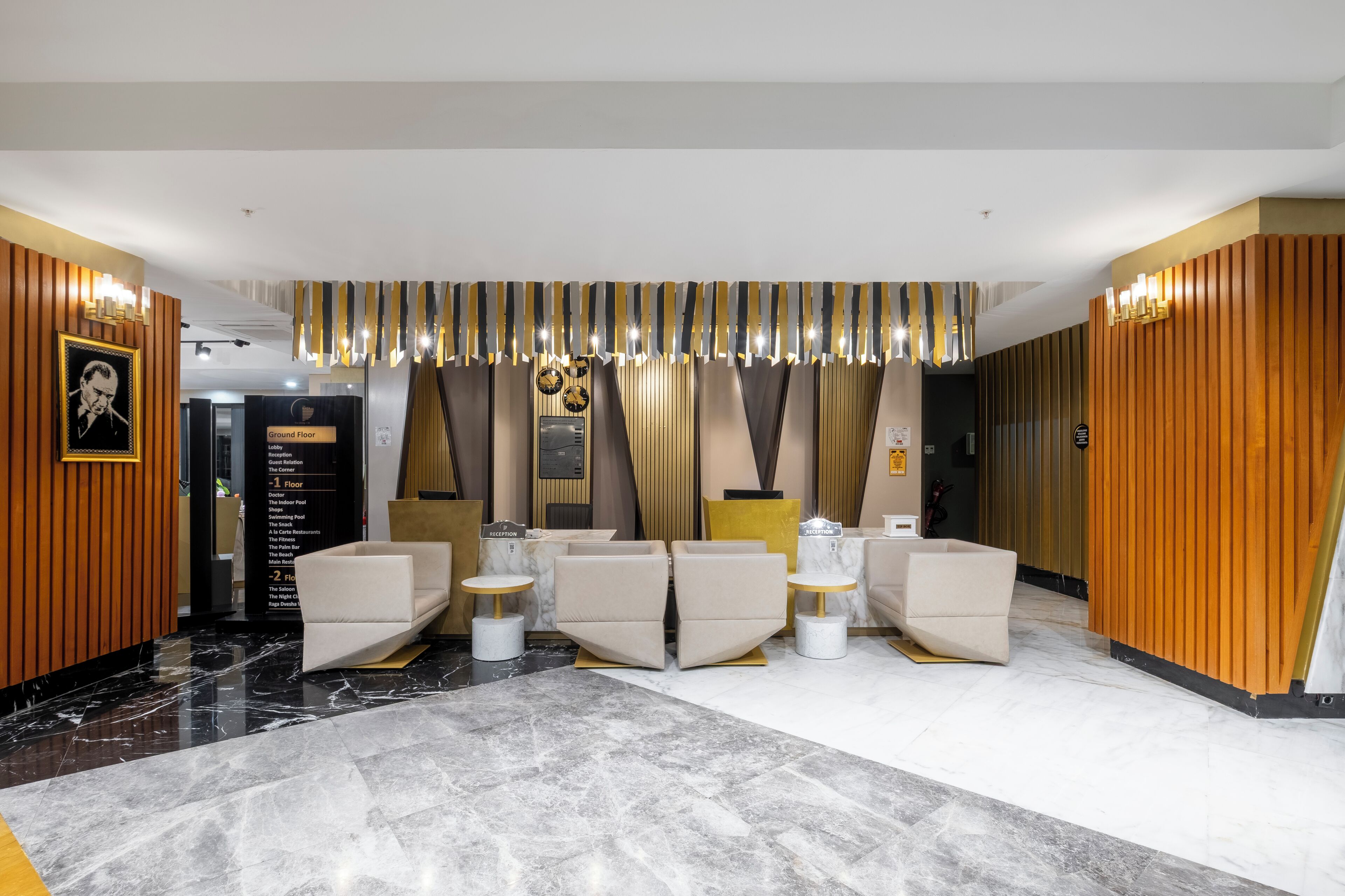 Um lobby moderno com balcão de recepção, área de estar e placa de informações.