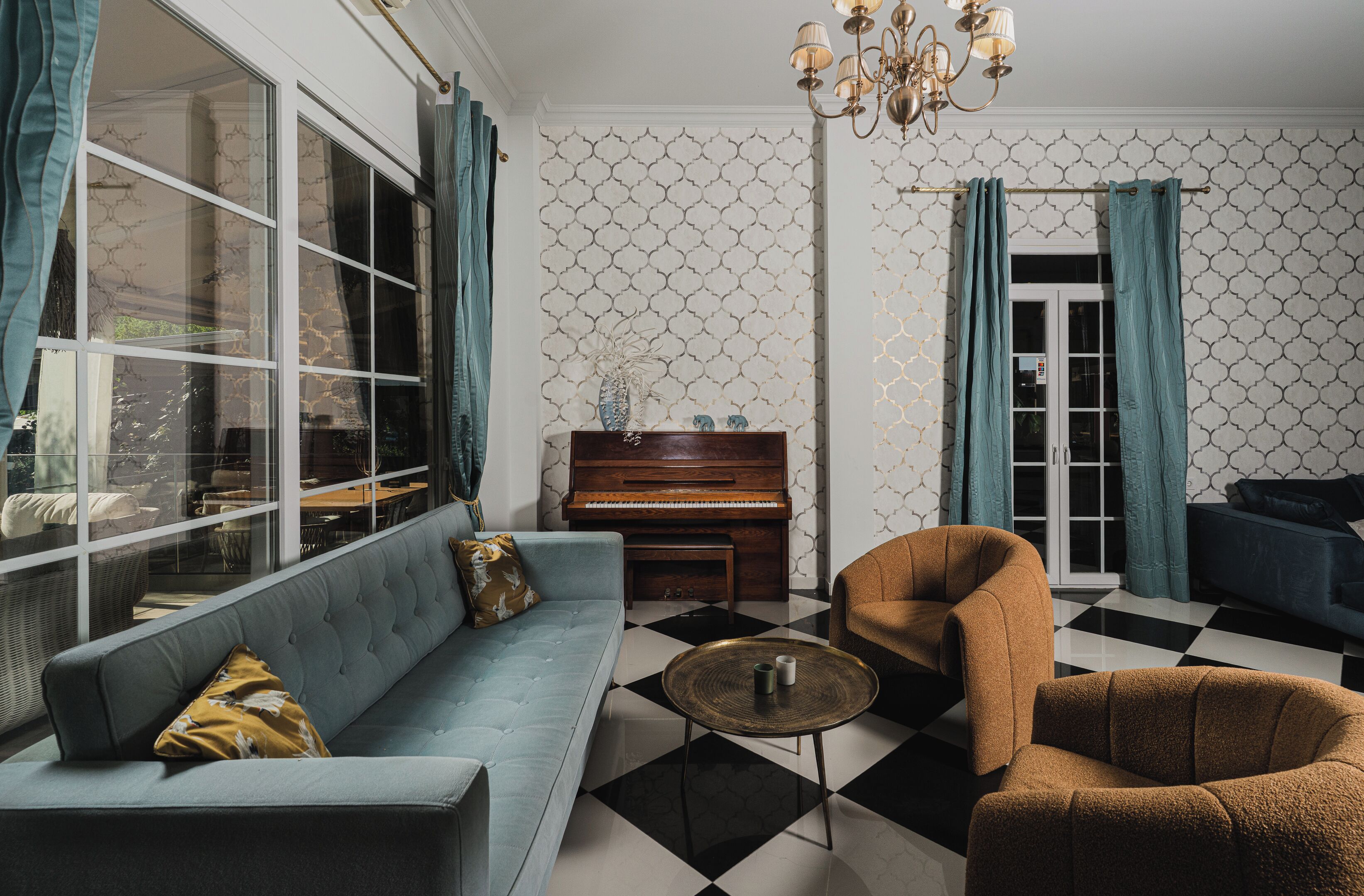 Uma sala de estar com sofá, poltrona e piano.
