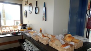 Disposição de buffet com diversos alimentos e utensílios sobre um balcão.