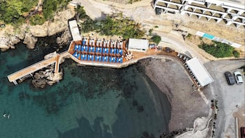 Uma praia privada, espreguiçadeiras, guarda-sóis de praia