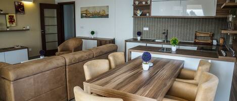 Uma sala de estar moderna com uma mesa de jantar de madeira e sofás bege.