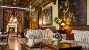Uma sala de estar ampla com sofás listrados, uma mesa de centro de madeira e um lustre.