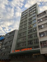 Um edifício de vários andares com uma placa que diz "homy residence", indicando que se trata de um imóvel residencial.
