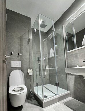 Quarto Individual Deluxe | Casa de banho | Um polibã, artigos de higiene pessoal grátis, chinelos 