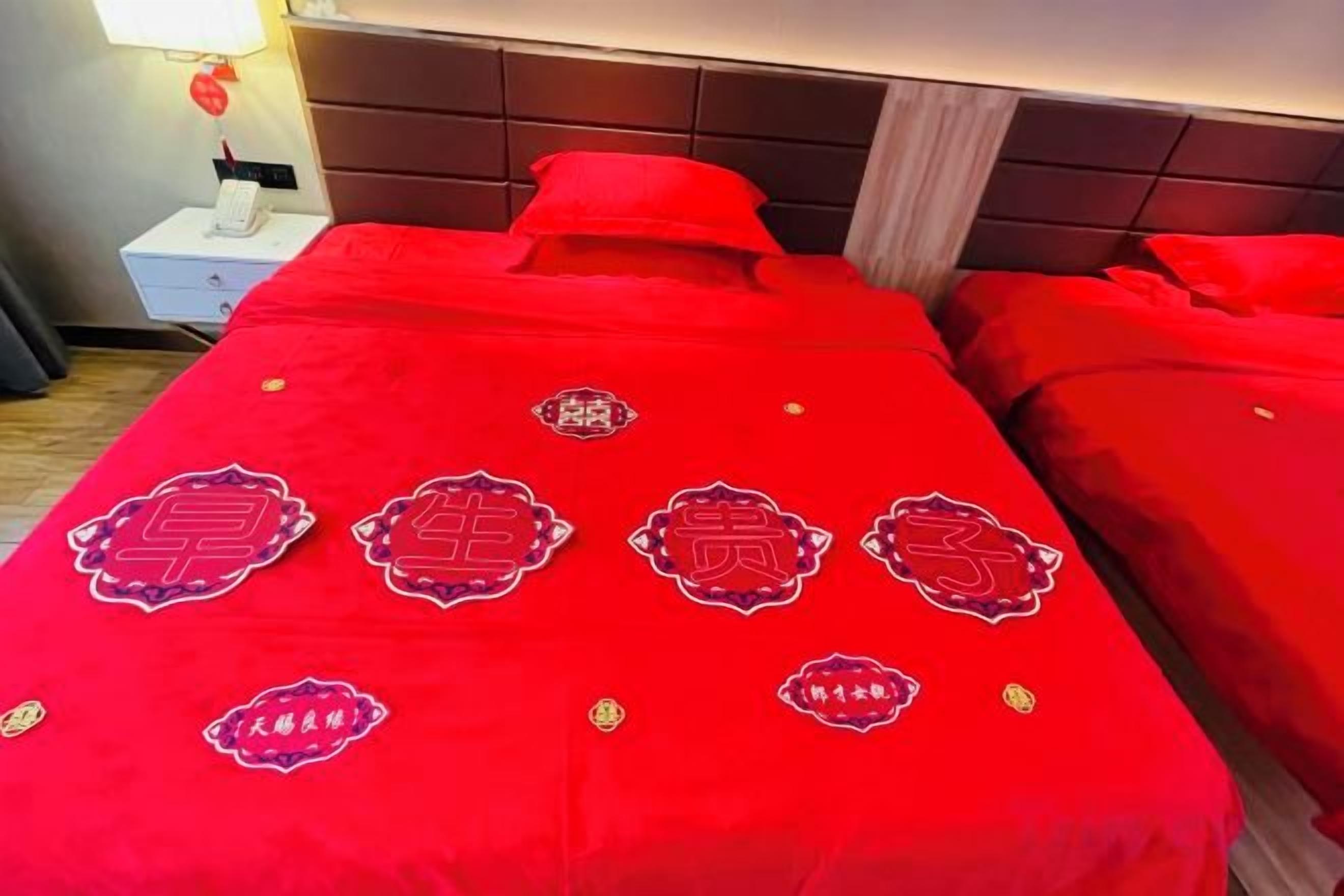 Quarto de hotel com uma cama, mesa de cabeceira e abajur.