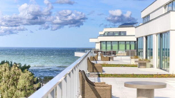 Um edifício moderno com amplas janelas com vista para o mar.