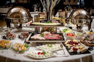 Mesa de buffet com diversos alimentos e um aviso indicando 'HEAT'.