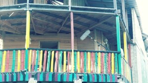 Um edifício de dois andares com uma varanda e grades coloridas.