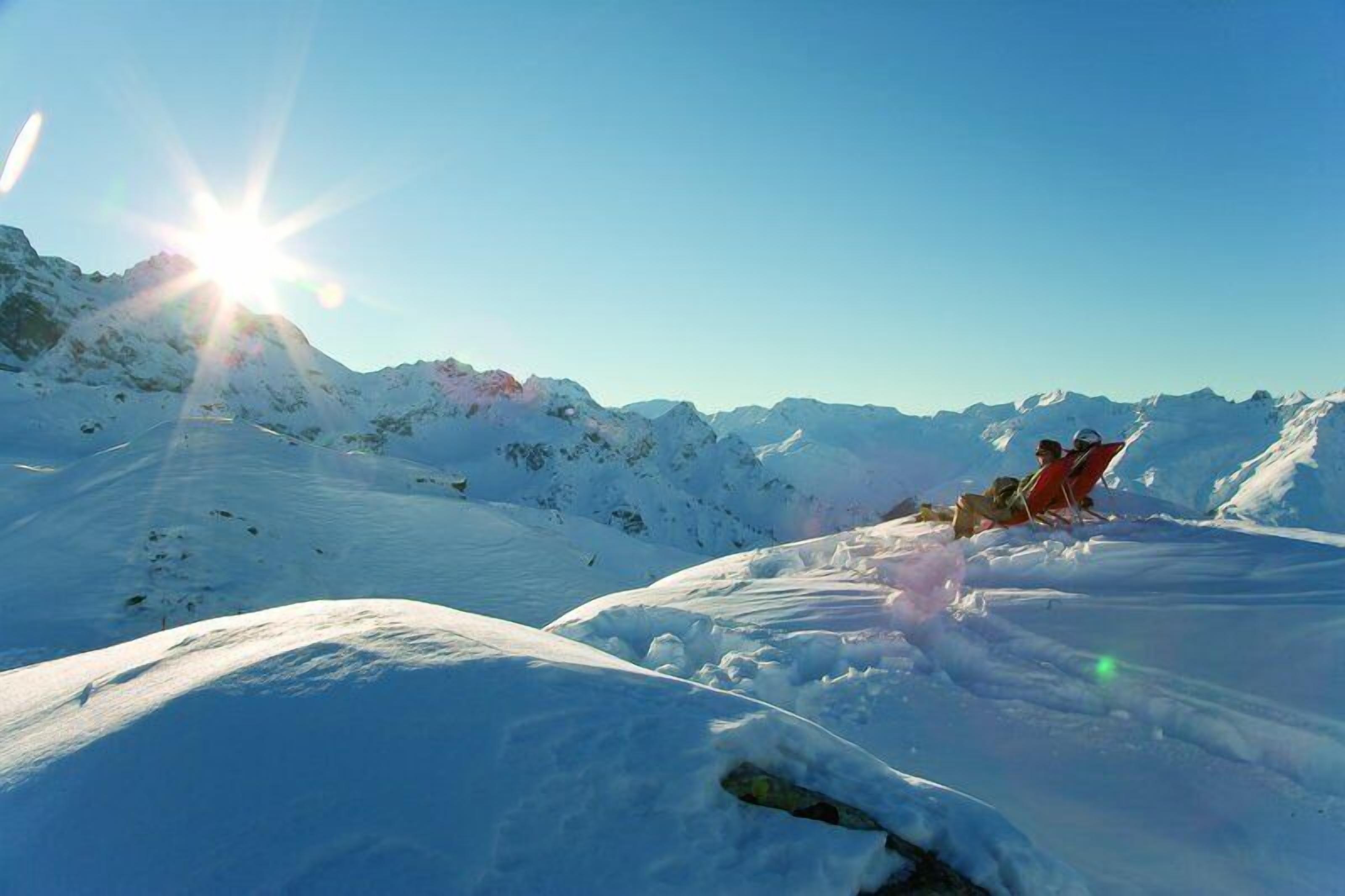 Paisagem montanhosa coberta de neve sob um céu limpo.