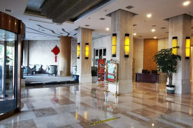 Um saguão de hotel com balcão de recepção, área de estar e palco.