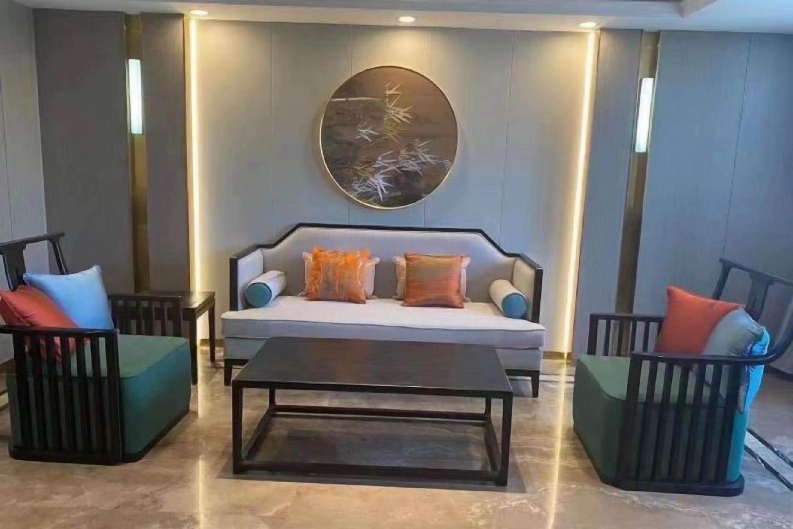 Uma área de estar moderna com um sofá, duas poltronas e uma mesa de centro.