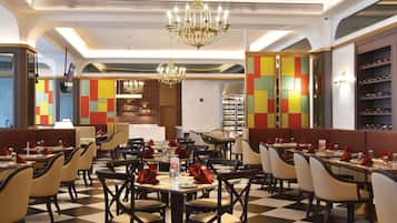 Um restaurante com chão xadrez, várias mesas de jantar e cabines.