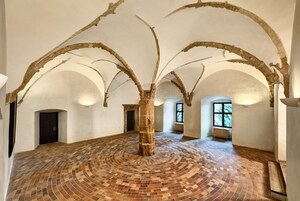 Um salão amplo com piso de tijolos em formato circular e tetos em arco.