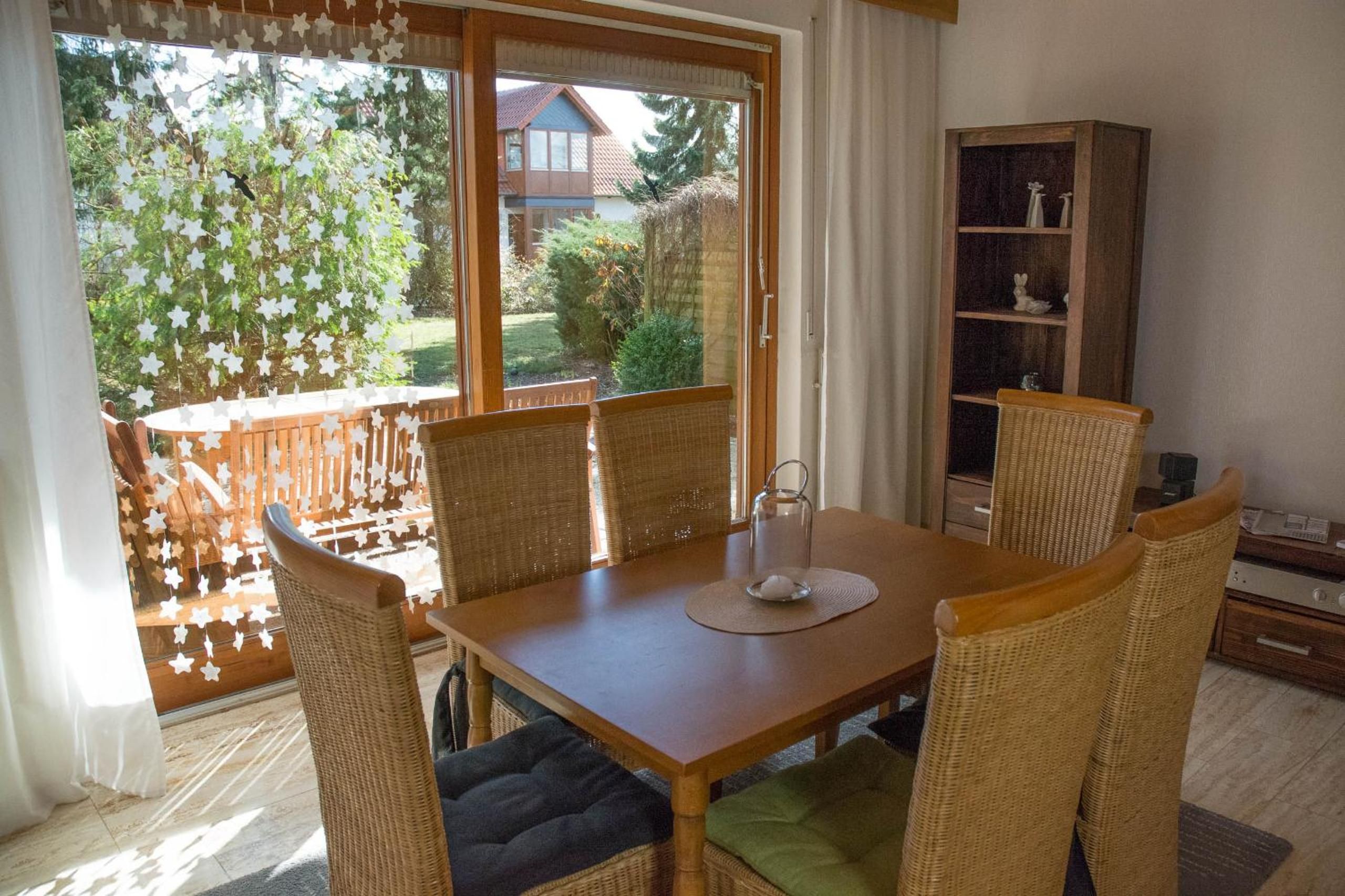 Uma área de jantar com mesa e cadeiras, um compartimento envidraçado e vista para o exterior.