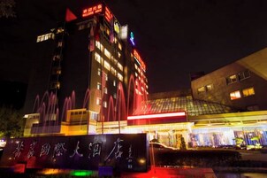 Um hotel com vários andares e uma fonte grande em destaque na frente.
