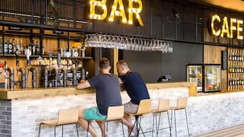 Um bar e café com design moderno, apresentando um balcão com várias torneiras e um suporte para vinhos.