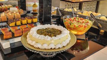 Buffet com diversos doces e salada de frutas.