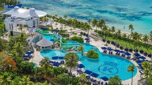 Um resort com uma piscina grande, um tobogã e uma área de praia.