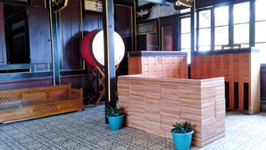 Quarto tradicional com esteiras de tatame, um armário de madeira e um grande tambor.