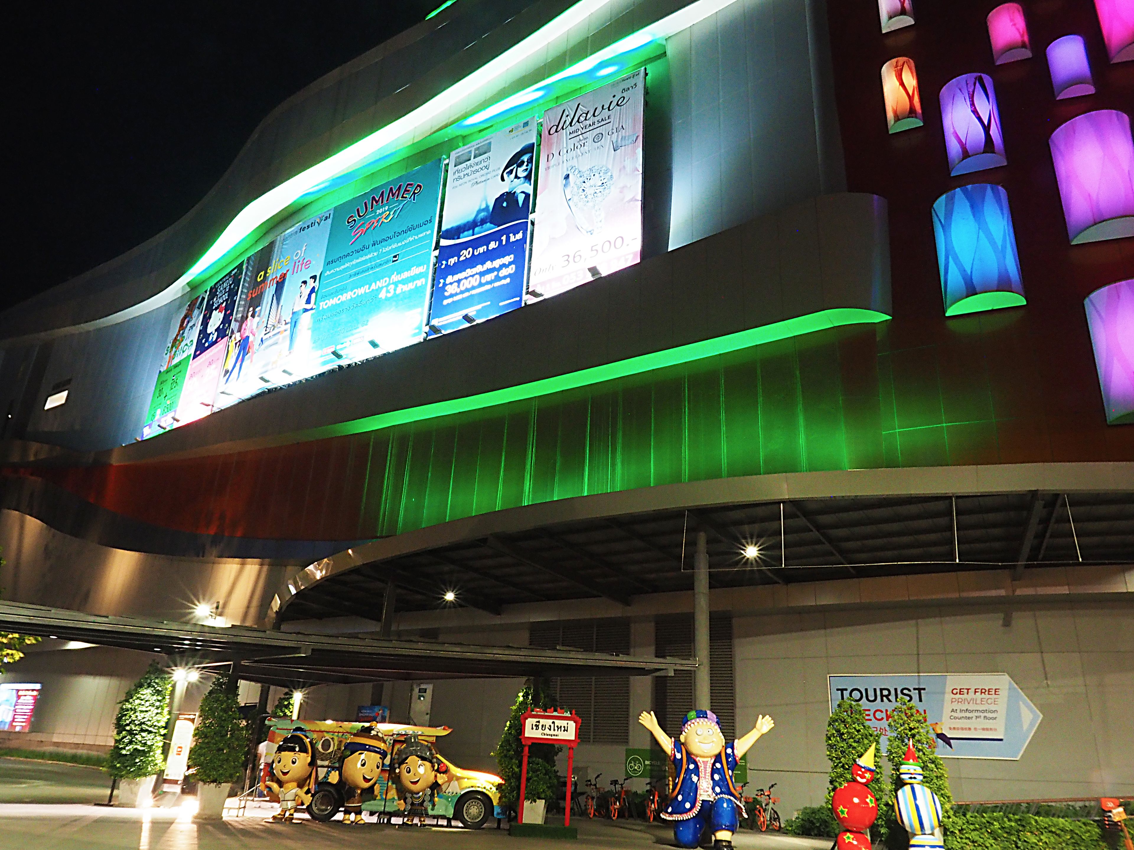 Um edifício com letreiros iluminados anunciando diversos eventos e promoções.