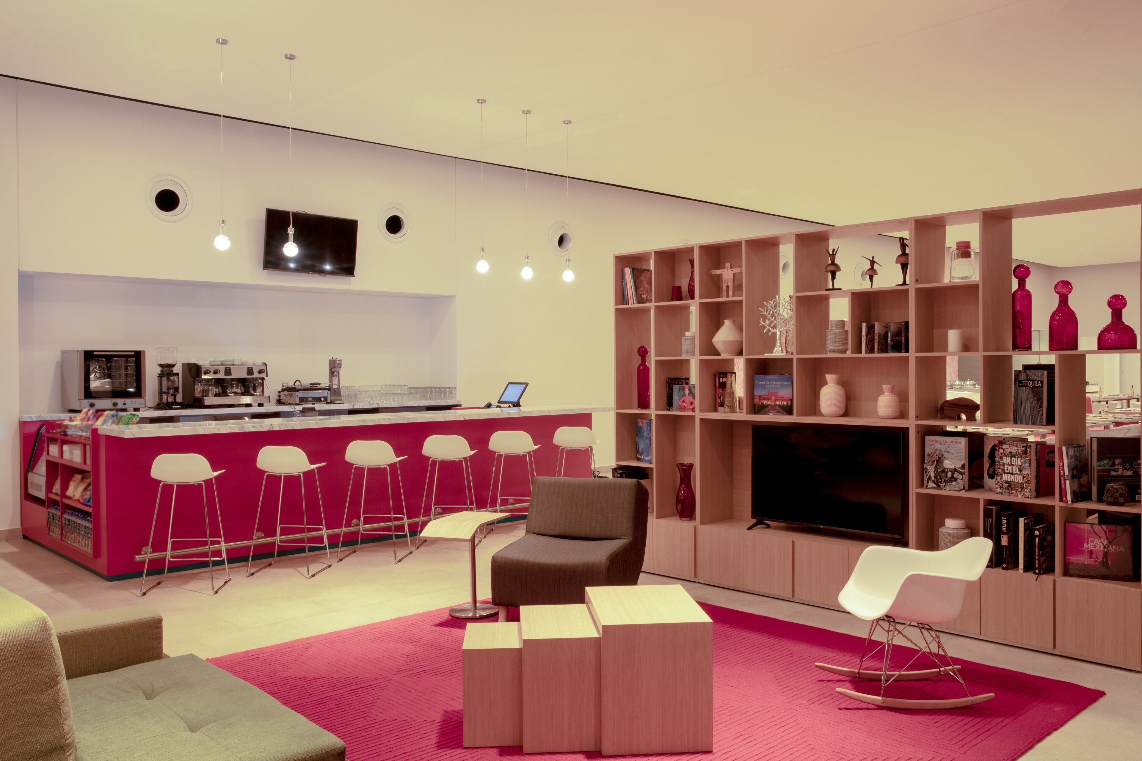 Uma sala de estar moderna com área de bar, televisão e estante de livros.