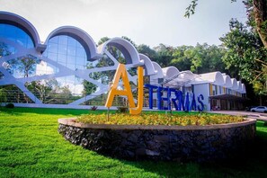 Um edifício moderno com uma grande placa 'AJ TERMS' em frente.