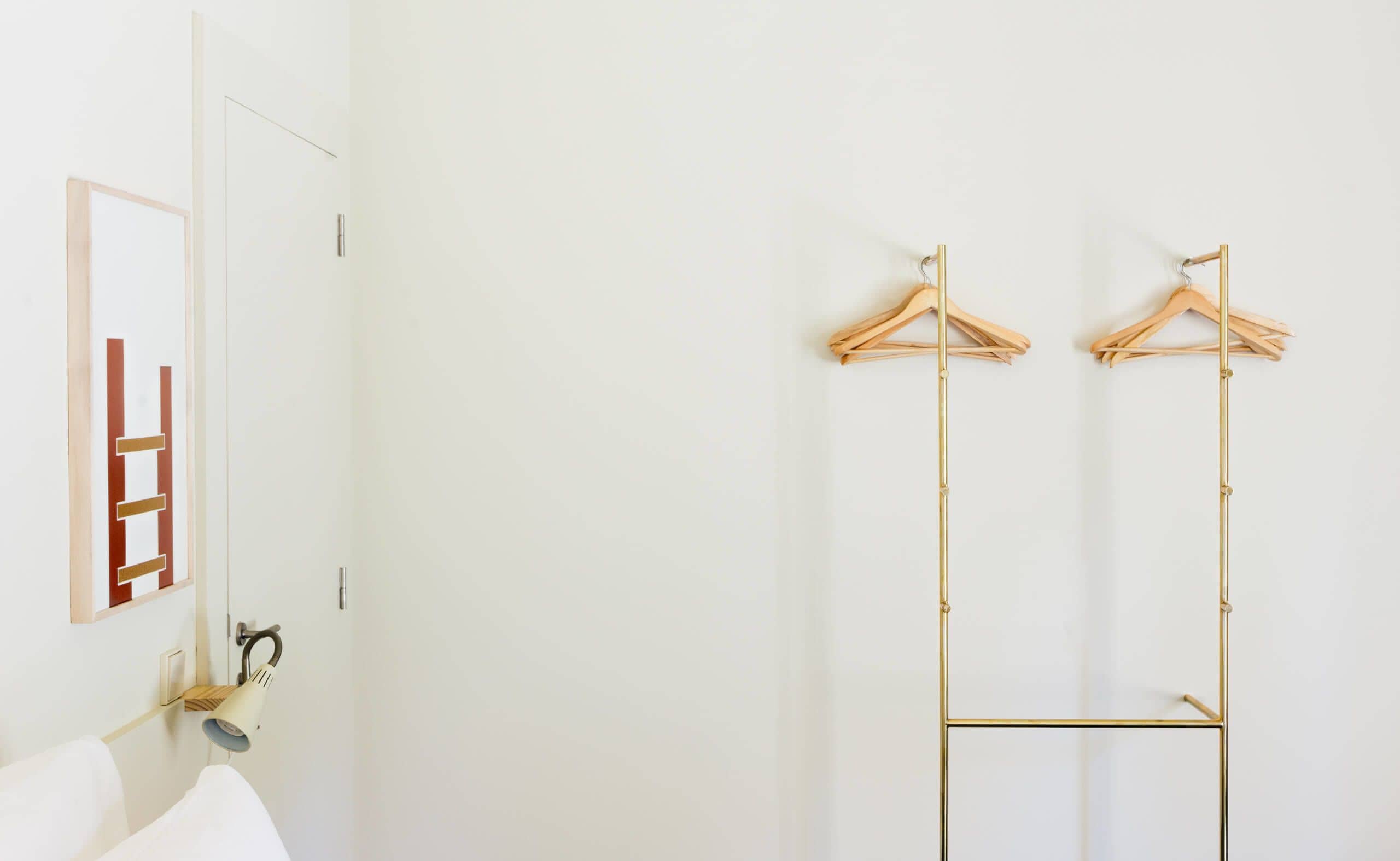 Um banheiro minimalista com pia branca, espelho e porta-toalhas.