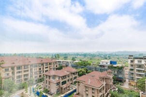Um complexo residencial com vários edifícios de apartamentos, piscina e vista para a paisagem circundante.