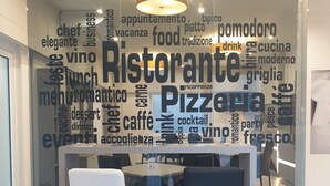 Interior moderno de restaurante com um mural de palavras destacando opções de comida e bebida.