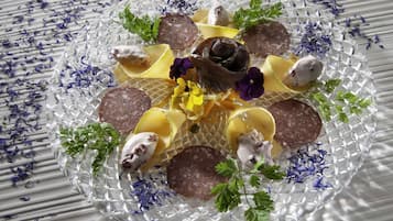 Um prato de vidro com diversos alimentos e flores.
