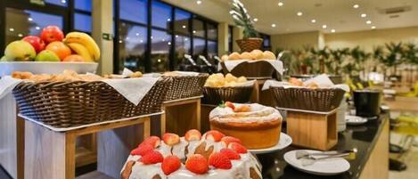 Um buffet com diversos pães e frutas.