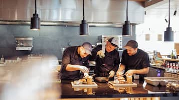 Cozinha moderna com eletrodomésticos de aço inoxidável e luminárias pendentes.
