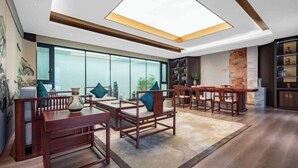 Uma sala de estar moderna com um grande claraboia, móveis de madeira e uma janela ampla.