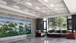 Um hall amplo com um mural grande, móveis modernos e janelas grandes com vista para o verde.