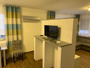 Cobertura luxo, 1 cama Queen e sofá-cama | Área de estar | TV de tela plana