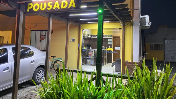 Um edifício com uma placa que diz "POUSADA" e o número 318.