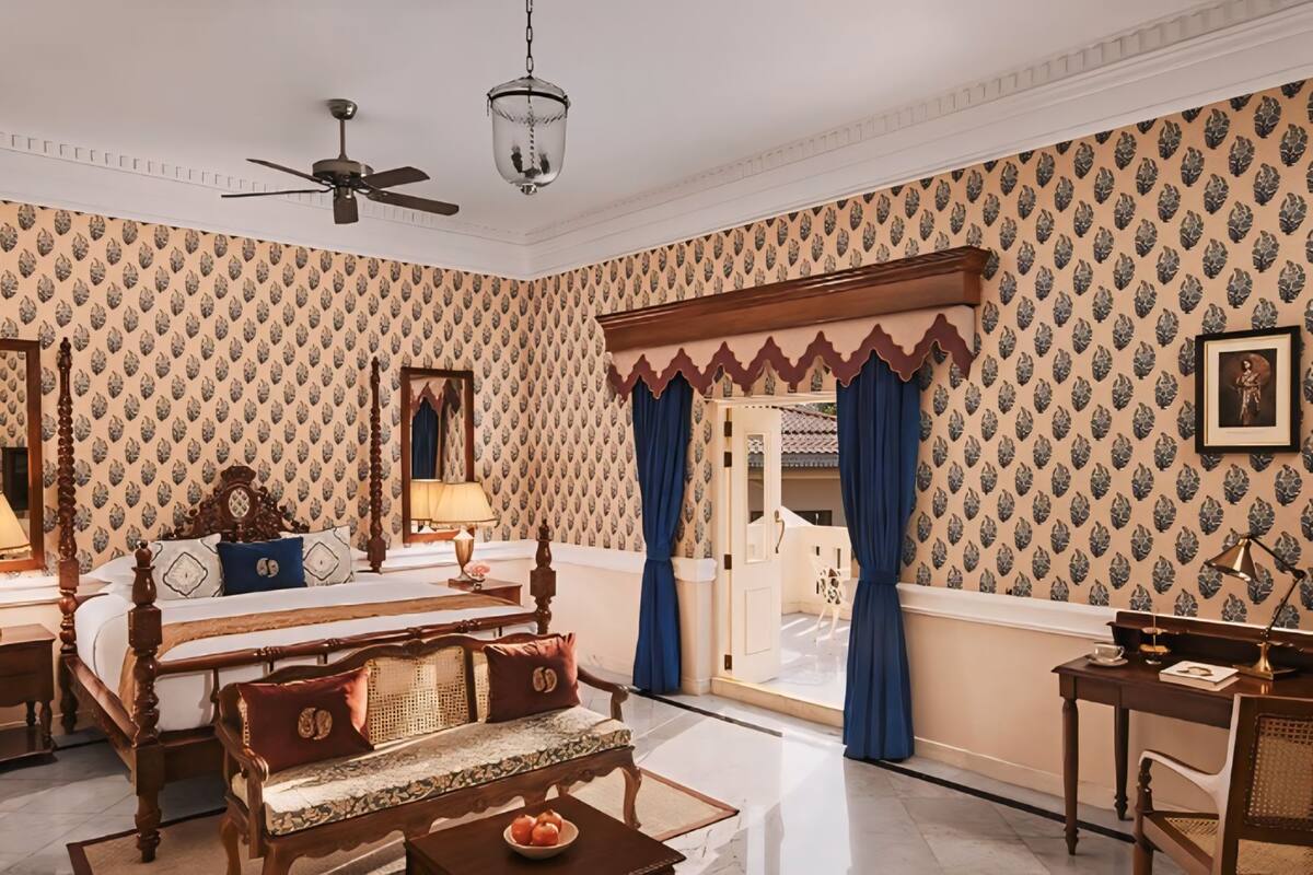 Quarto espaçoso com uma cama grande, um espaço para sentar e uma mesa de trabalho.