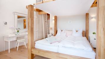 Um quarto com uma cama beliche, uma escrivaninha, uma cadeira e uma mesa de cabeceira com abajur.