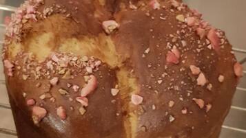 Uma barra de pão com cobertura rosa e branca sobre uma grade de metal.