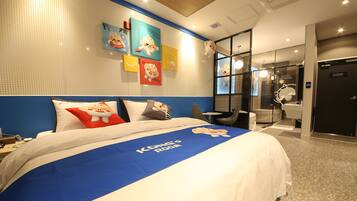 Quarto de hotel com cama, escrivaninha e banheiro.
