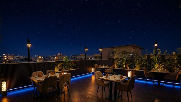 Restaurante no terraço com mesas, cadeiras, vista da cidade e iluminação decorativa.