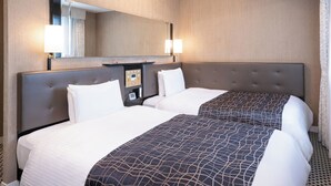 Quarto de hotel com duas camas, um espelho grande e um painel de controle na parede.