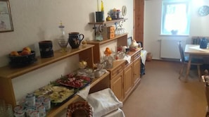 Uma cozinha com armários de madeira, uma mesa de jantar e diversos alimentos sobre o balcão.