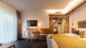 Quarto de hotel moderno com uma cama grande, uma escrivaninha e uma cadeira.