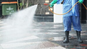Uma pessoa com equipamento de proteção utilizando um dispositivo de pulverização de água.