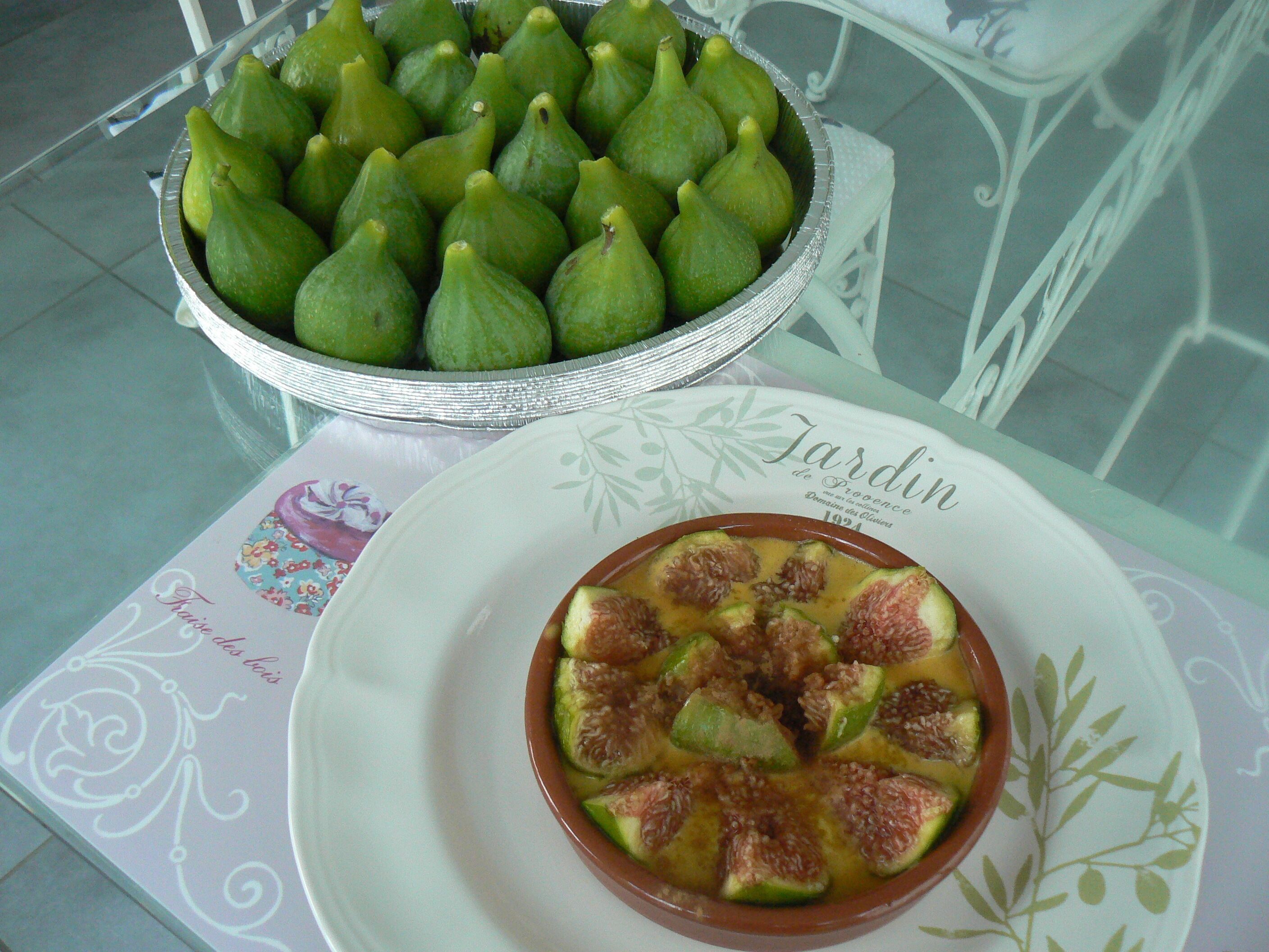 Uma mesa com uma tigela de figos verdes e um prato com um prato de figos.