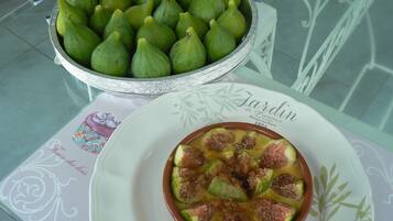 Uma mesa com uma tigela de figos verdes e um prato com um prato de figos.