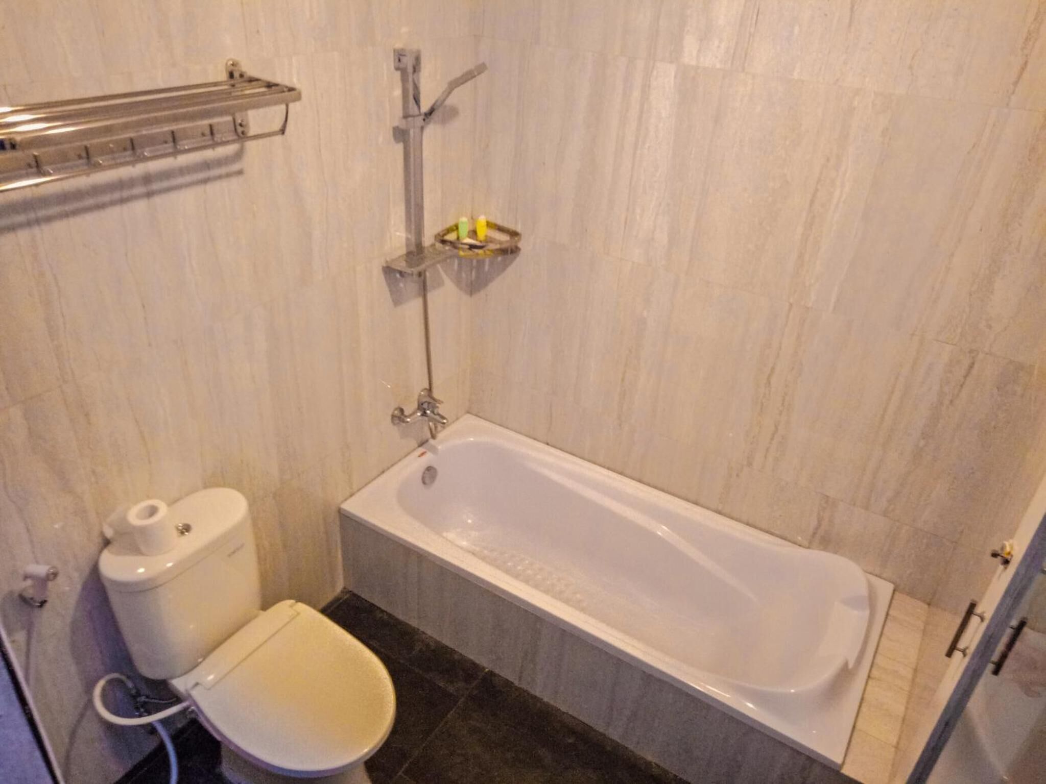 Casa de banho com banheira branca, sanita e zona de duche.