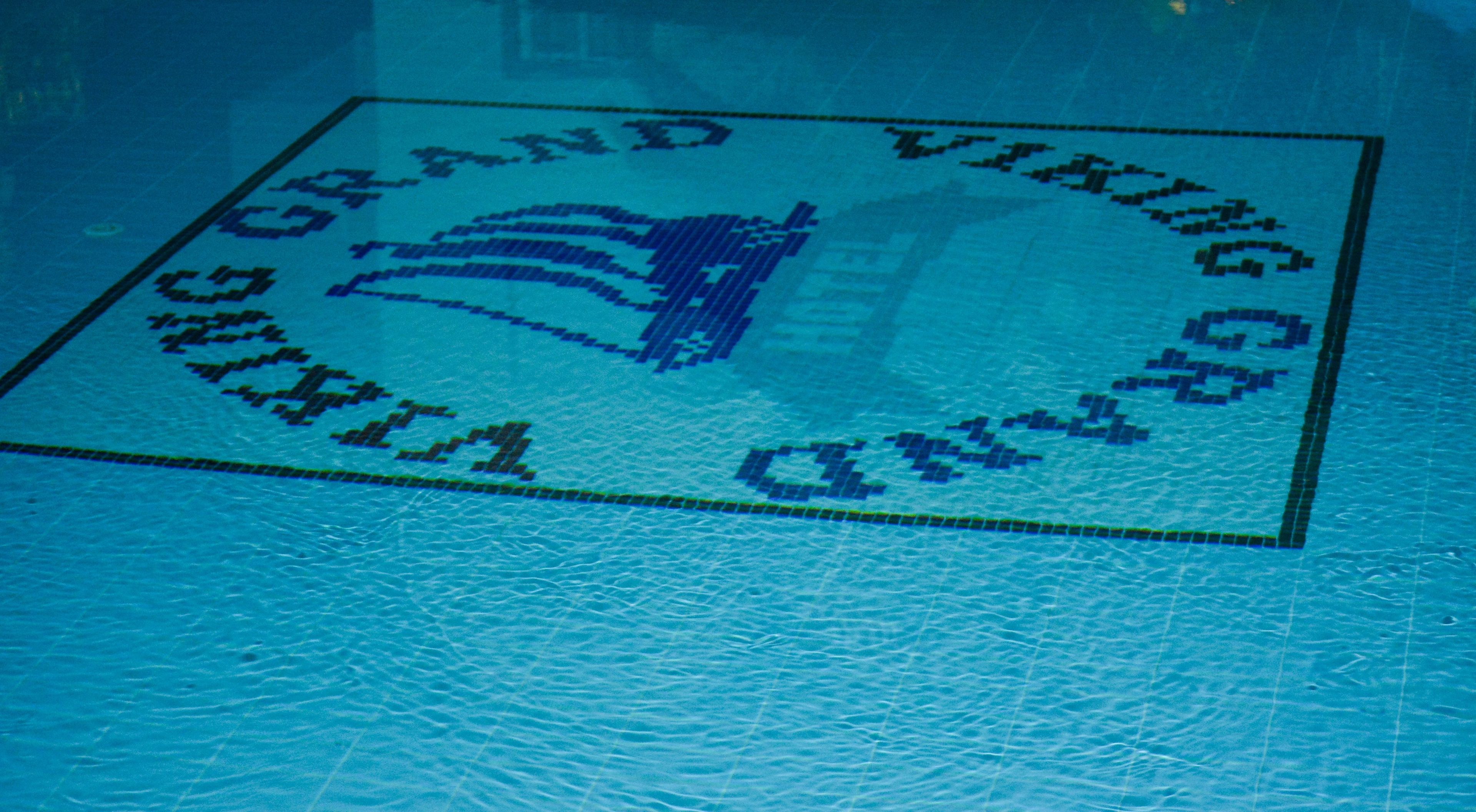 Uma piscina com um logotipo e texto indicando que faz parte do Grand Vail Resort.