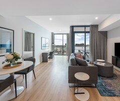 Uma sala de estar moderna com sofá, mesa de centro e área de refeições.